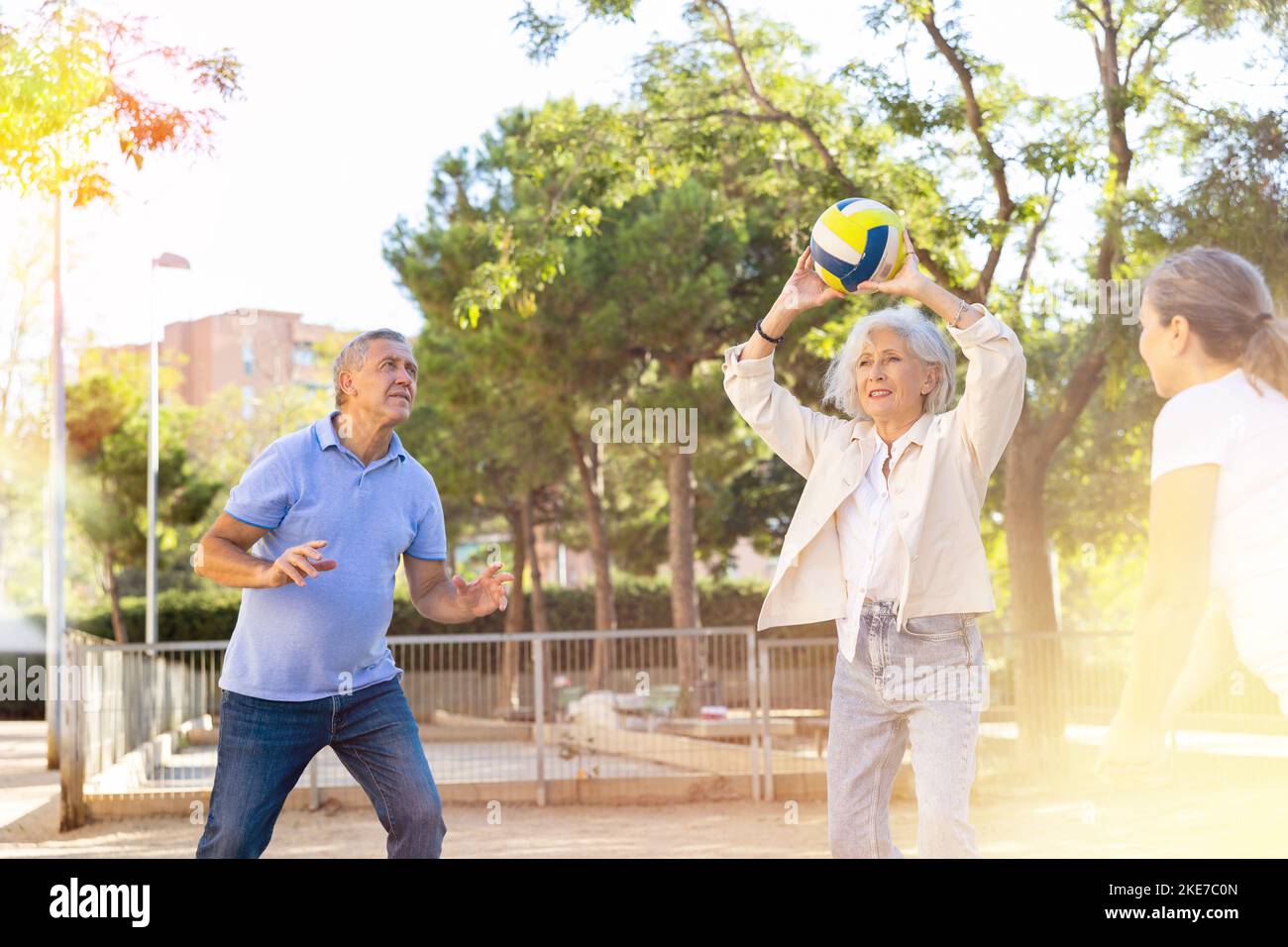 Positive multiracial friends of different ages throwing up a volleyball ...