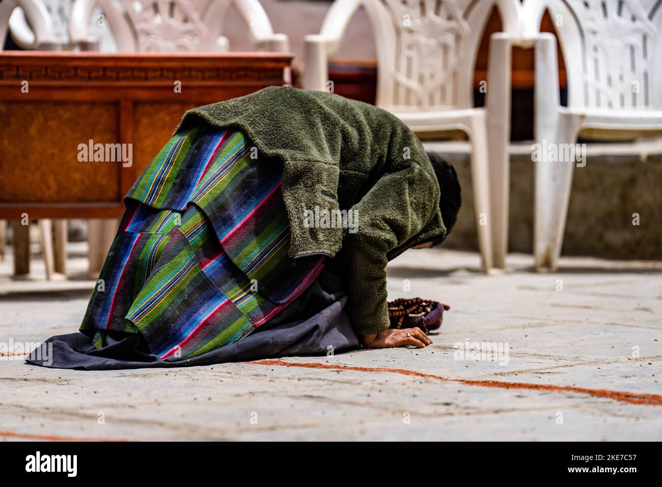 A closeup of an Adult Tibetan Buddhist worshiper in prostration at Tiji ...