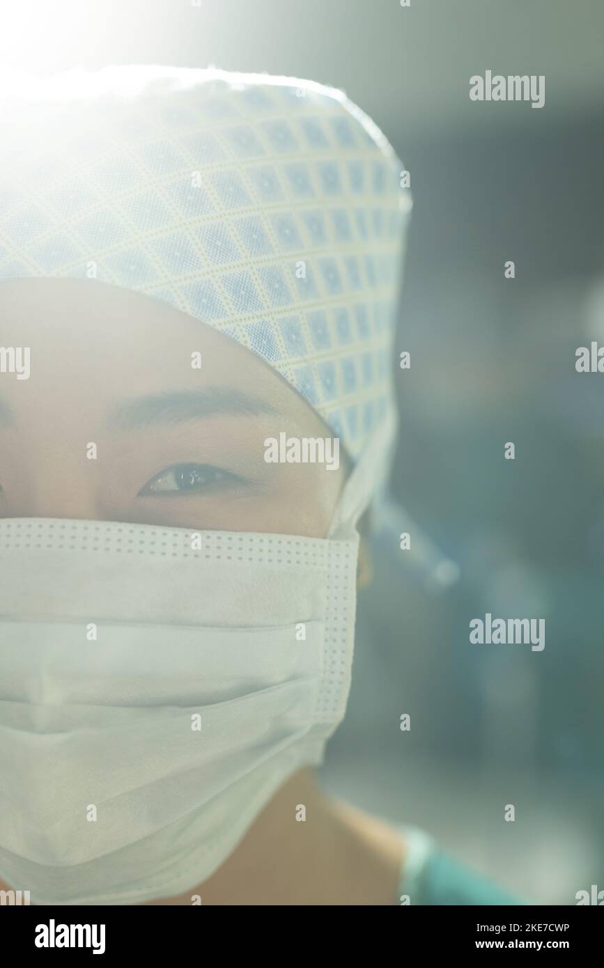 Vertical portrait of smiling asian female surgeon in surgical cap and ...