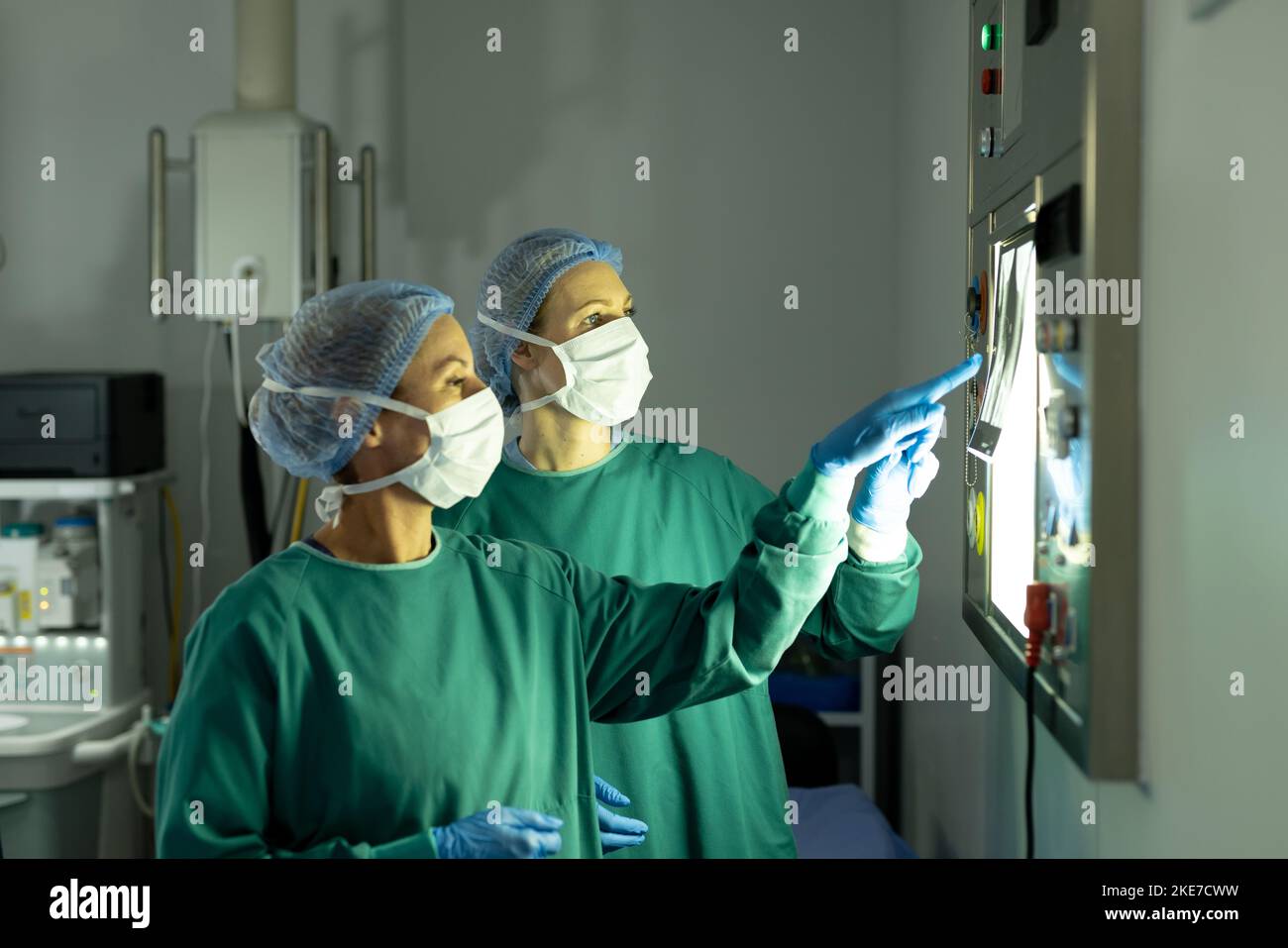 Two diverse female surgeons preparing for operation, studying x-ray in ...