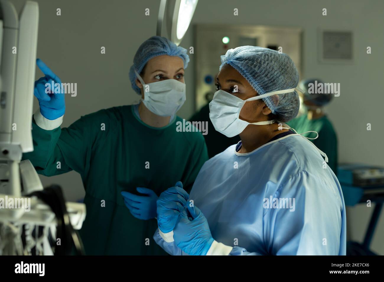 Diverse female surgeons in discussion, using medical equipment in ...