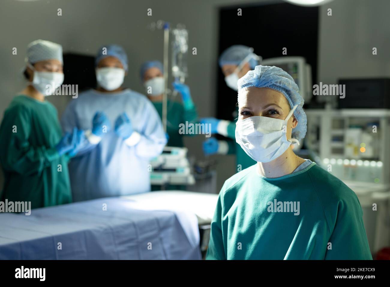 Portrait of smiling caucasian female surgeon in theatre for operation ...