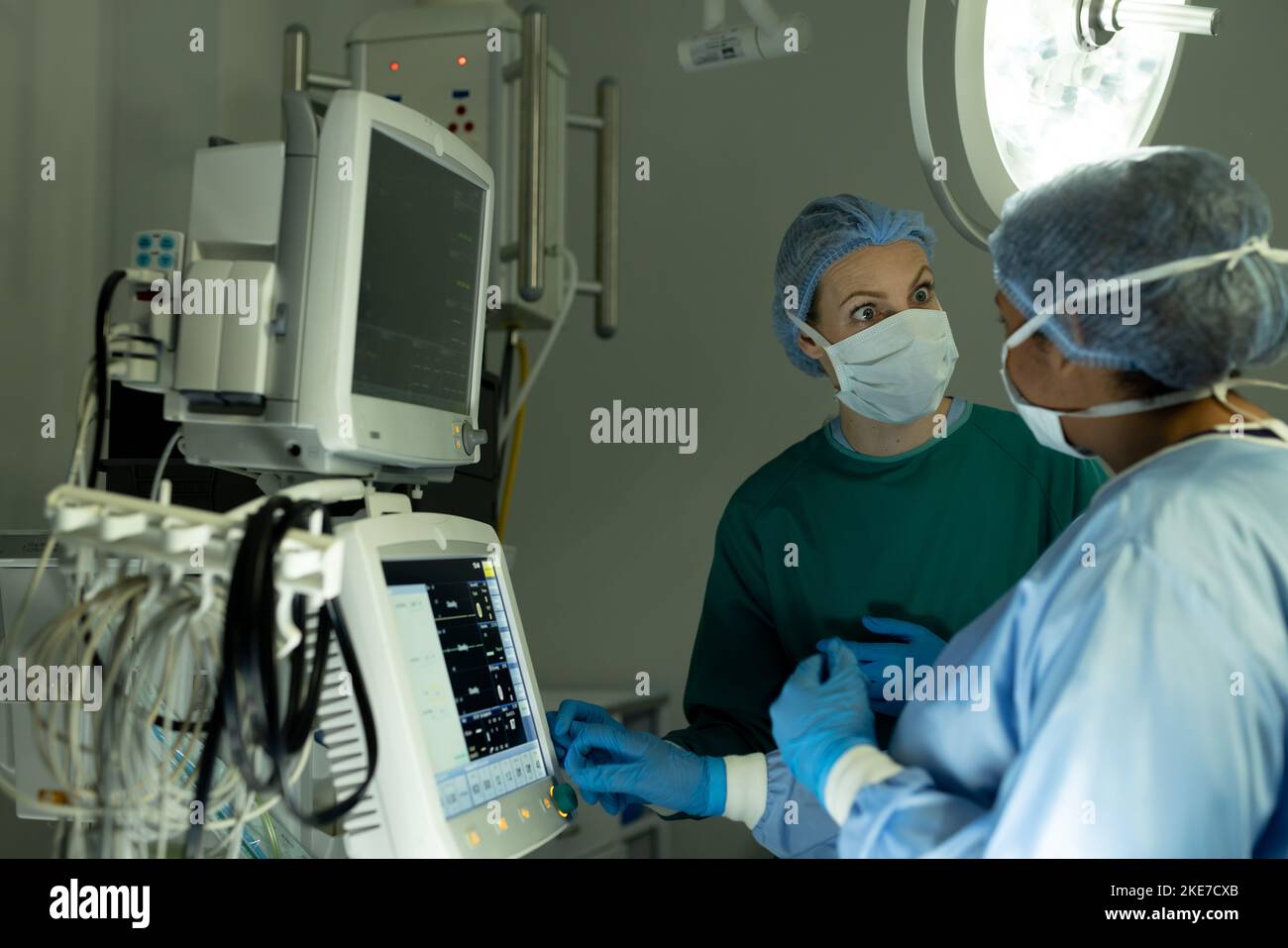 Diverse female surgeons in discussion, using medical equipment in ...