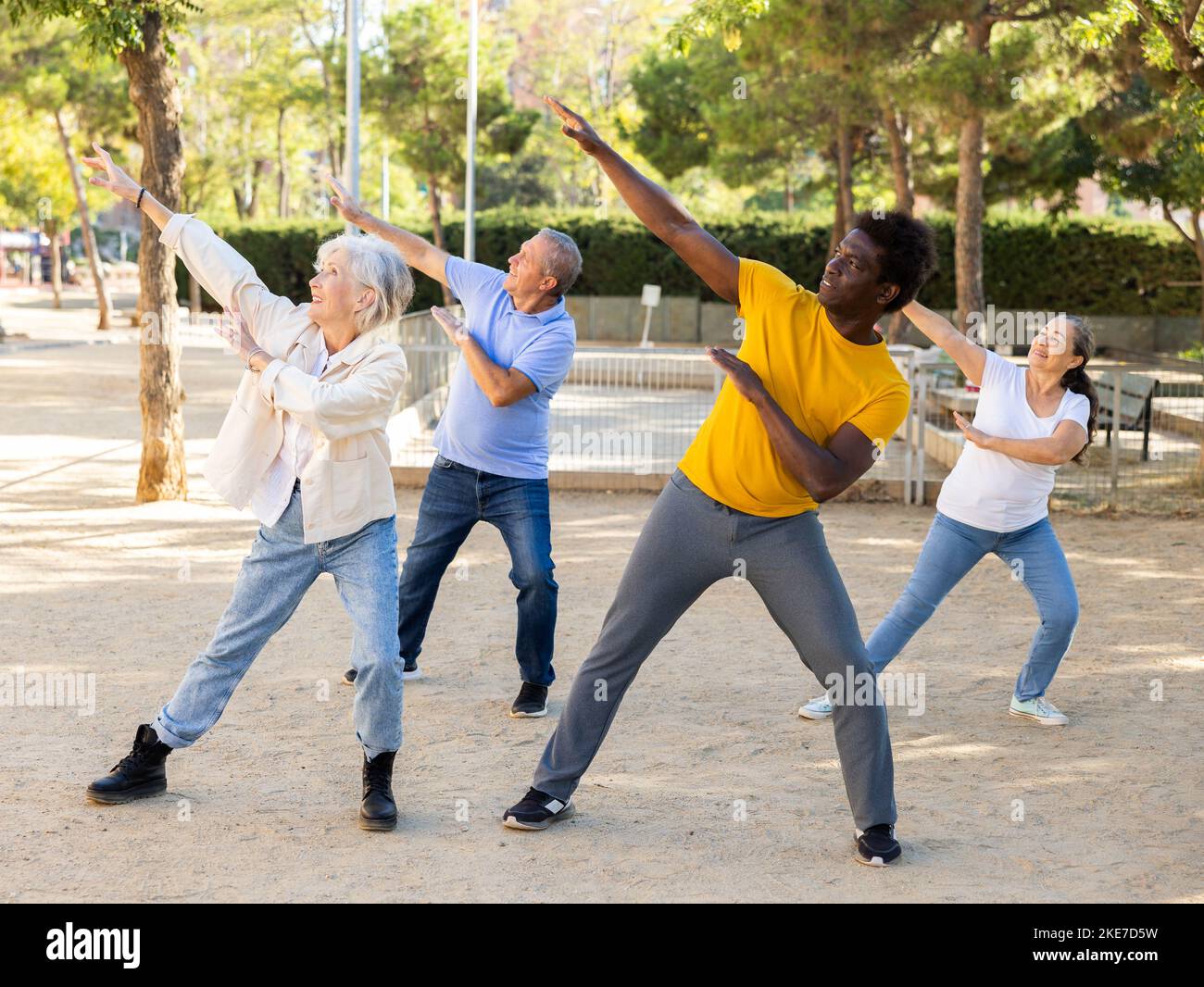 Group of happy women and men different ages practicing dance in summer ...