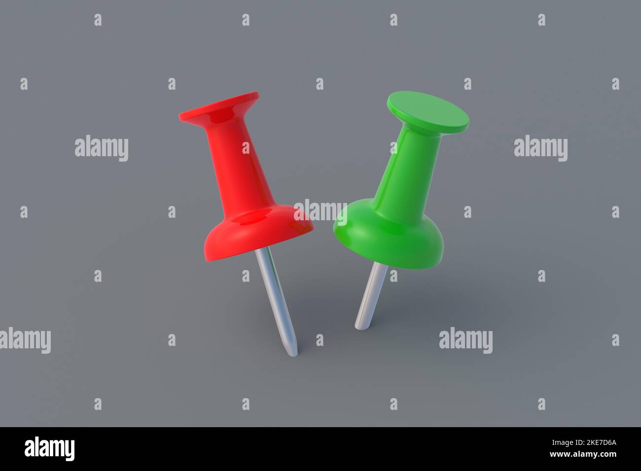 Two different color push pins on gray background. Stationery tools ...