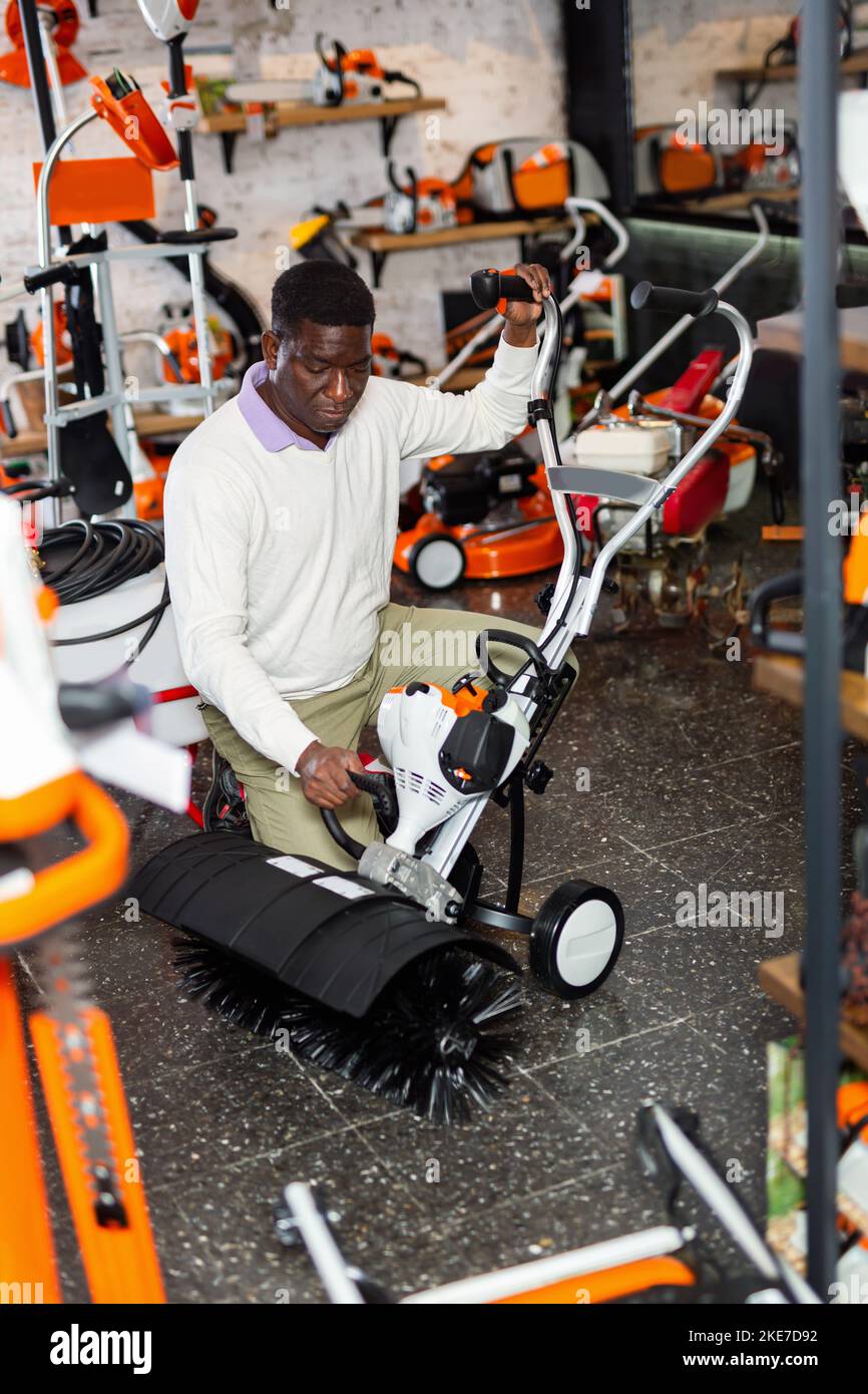 Customer takes close look at new street sweeper at tool store Stock ...