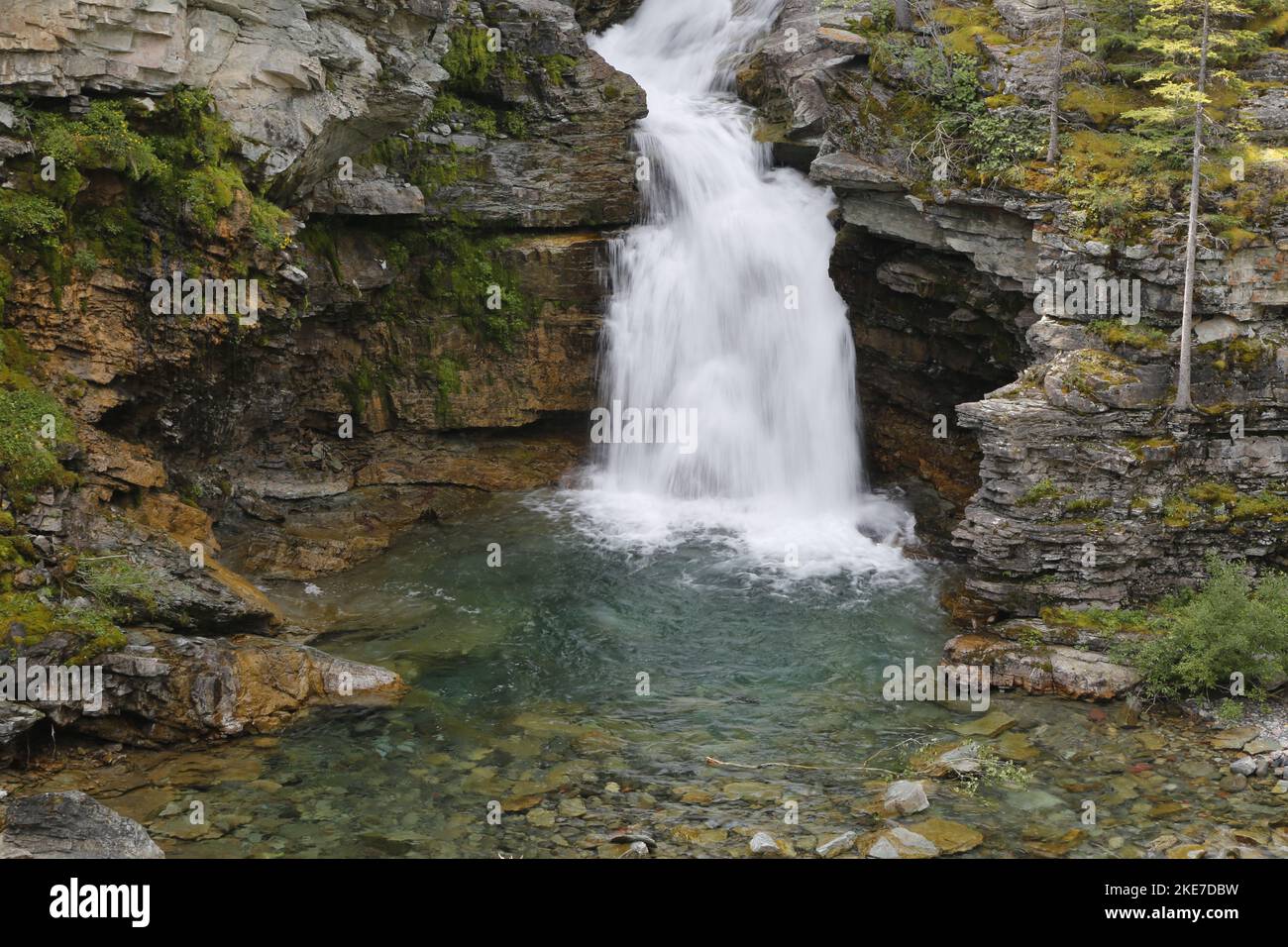 A vertical shot of a waterfall on a sunny day in a forest Stock Photo ...