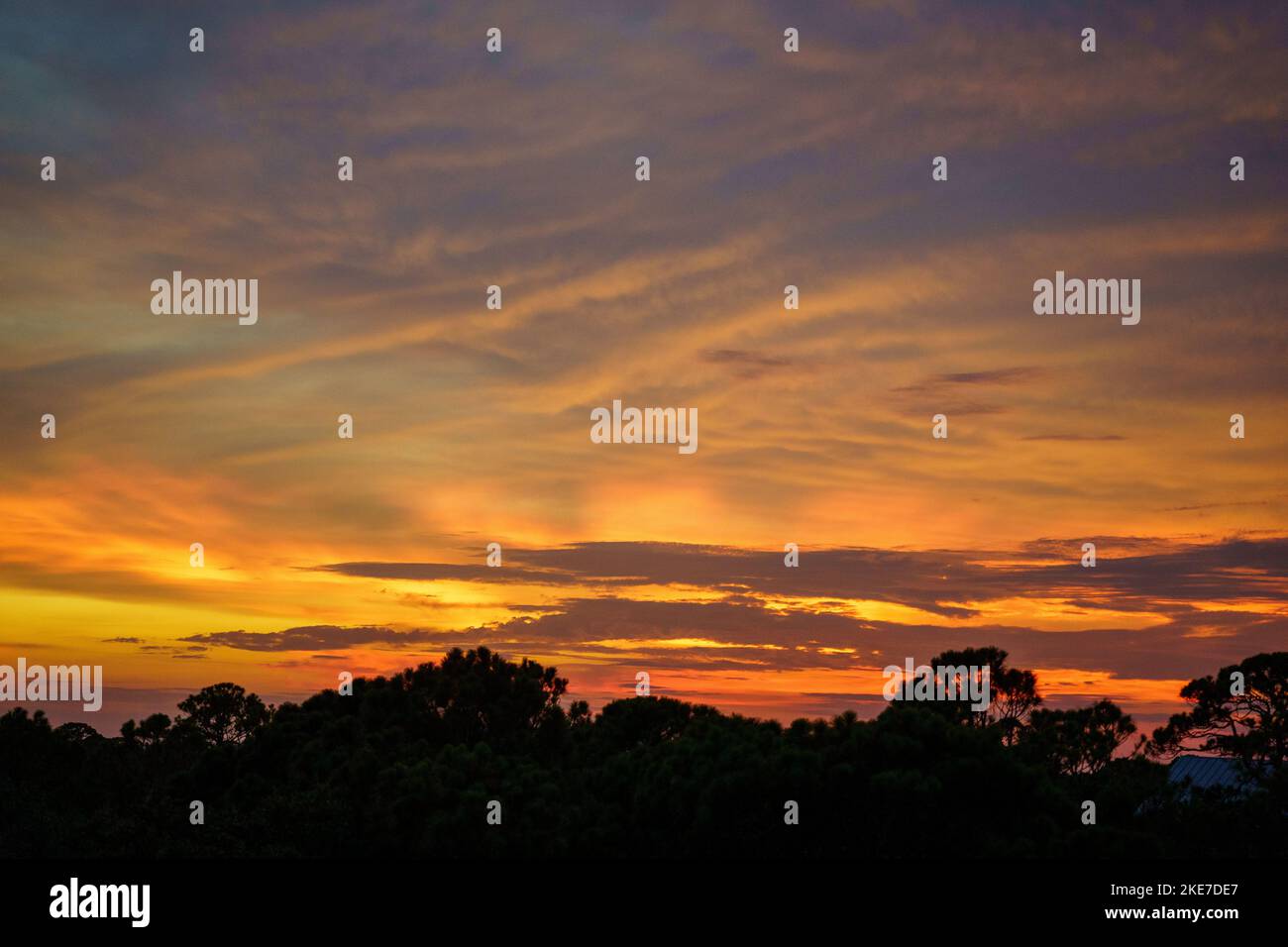 A breathtaking view of a sunset sky over green trees in Saint George ...