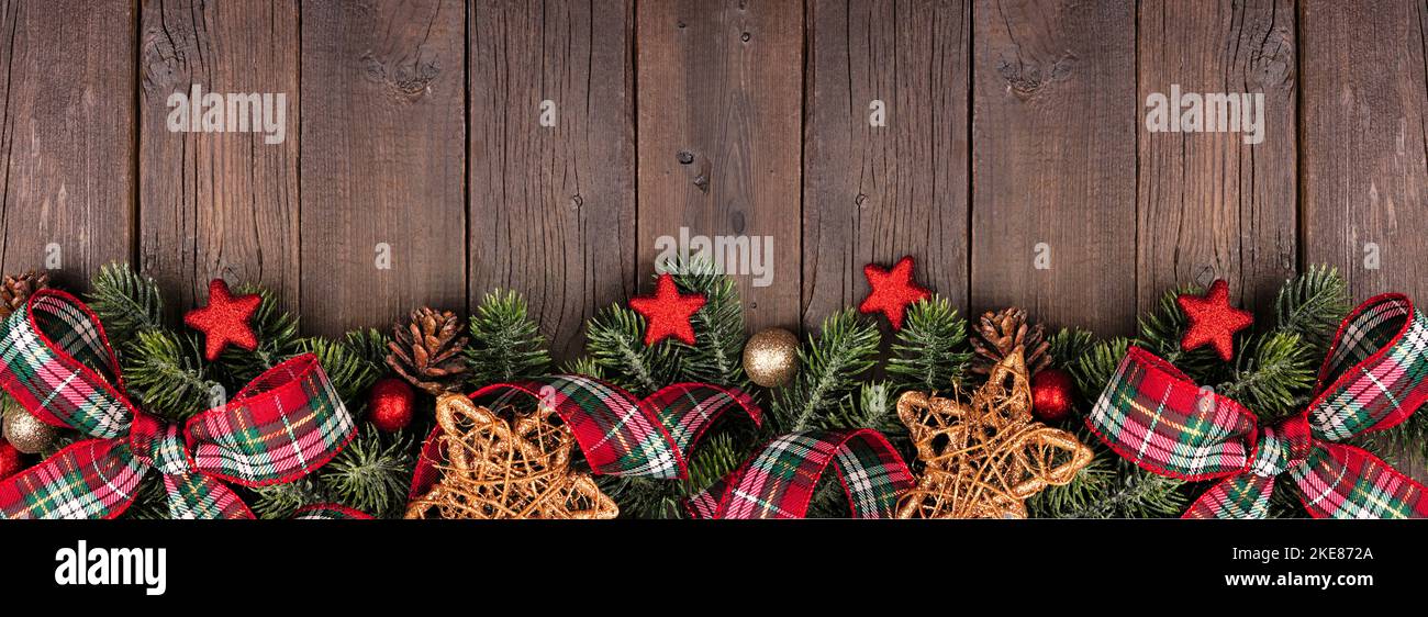 Christmas bottom border of ornaments, branches and red and green plaid ...