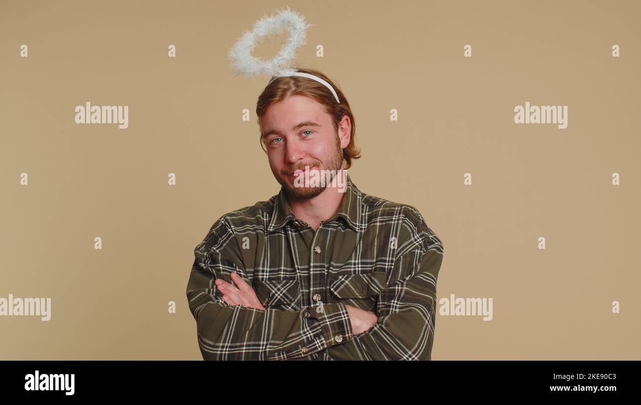 Portrait of smiling shy angelic young man with angel halo nimb over ...