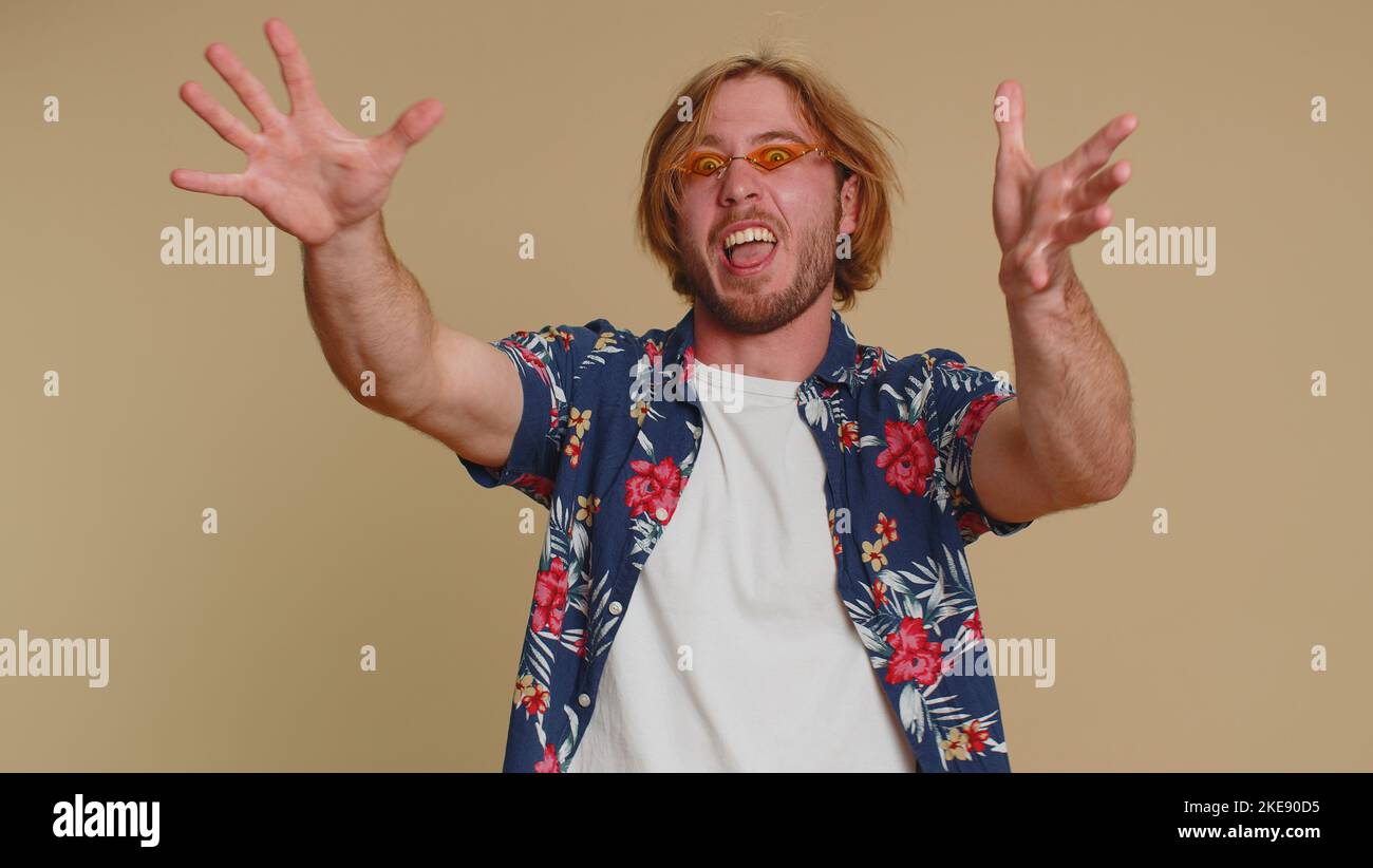 Little bit crazy. Blonde joyful sincere man demonstrating tongue out ...