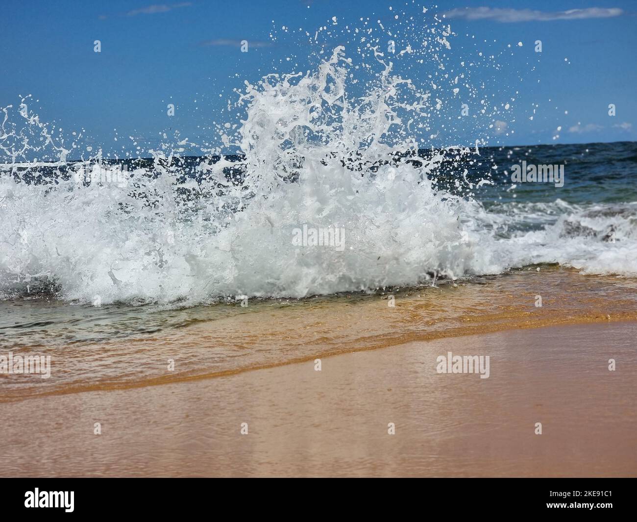 A wave splash on the sandy Pristine beach in Central Coast, Australia ...