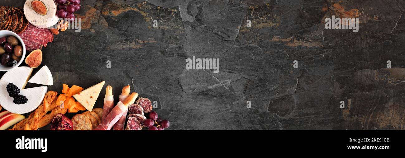 Selection of cheese and meat appetizers. Above view corner border on a ...