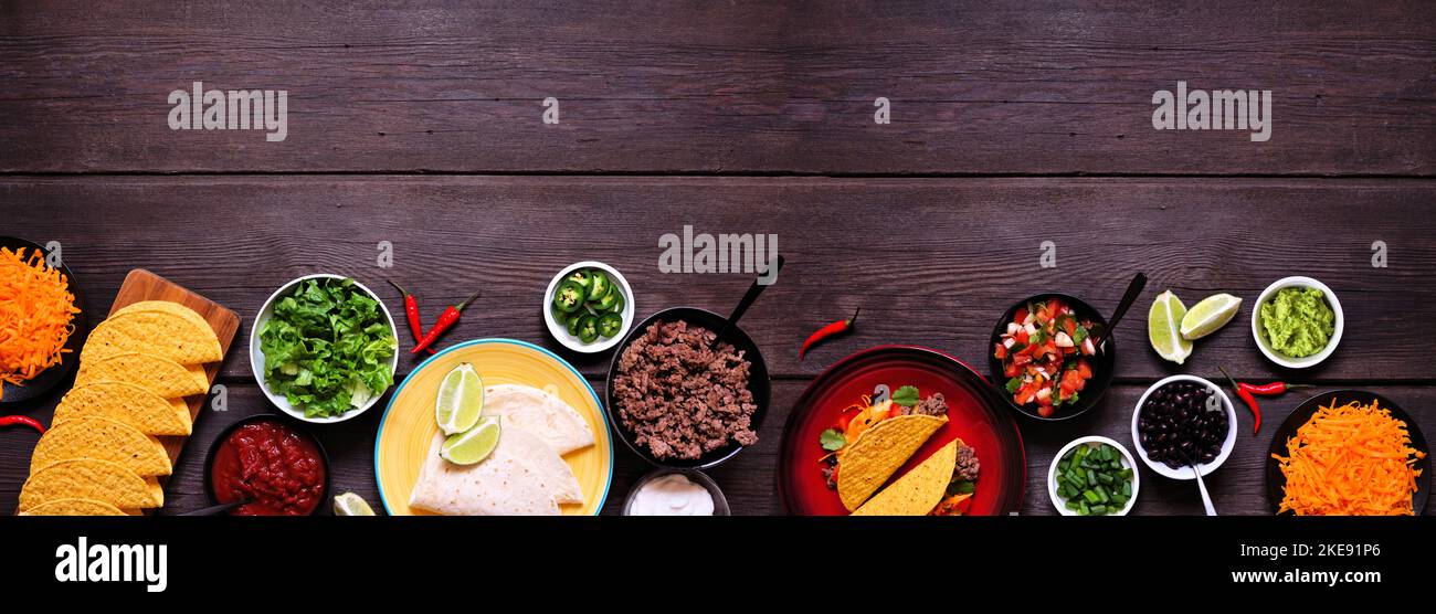 Taco bar bottom border with assorted ingredients. Top view on a dark ...