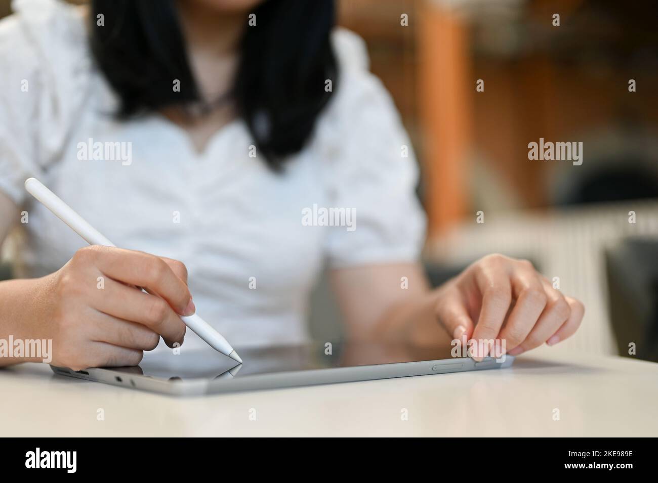 cropped shot, Young Asian female in casual clothes using stylus pen ...