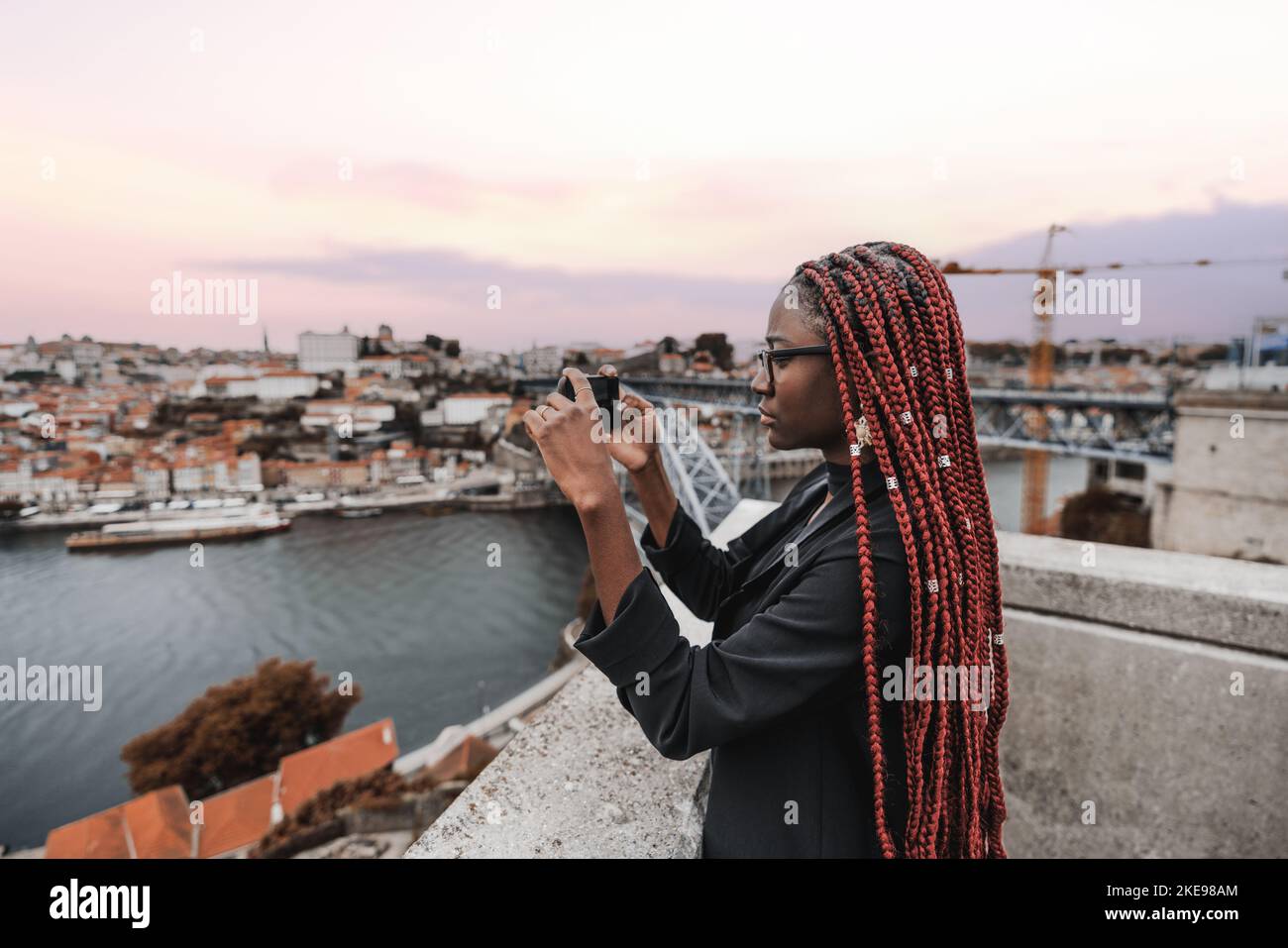 Side view of a charming young African woman in a black outfit, with ...