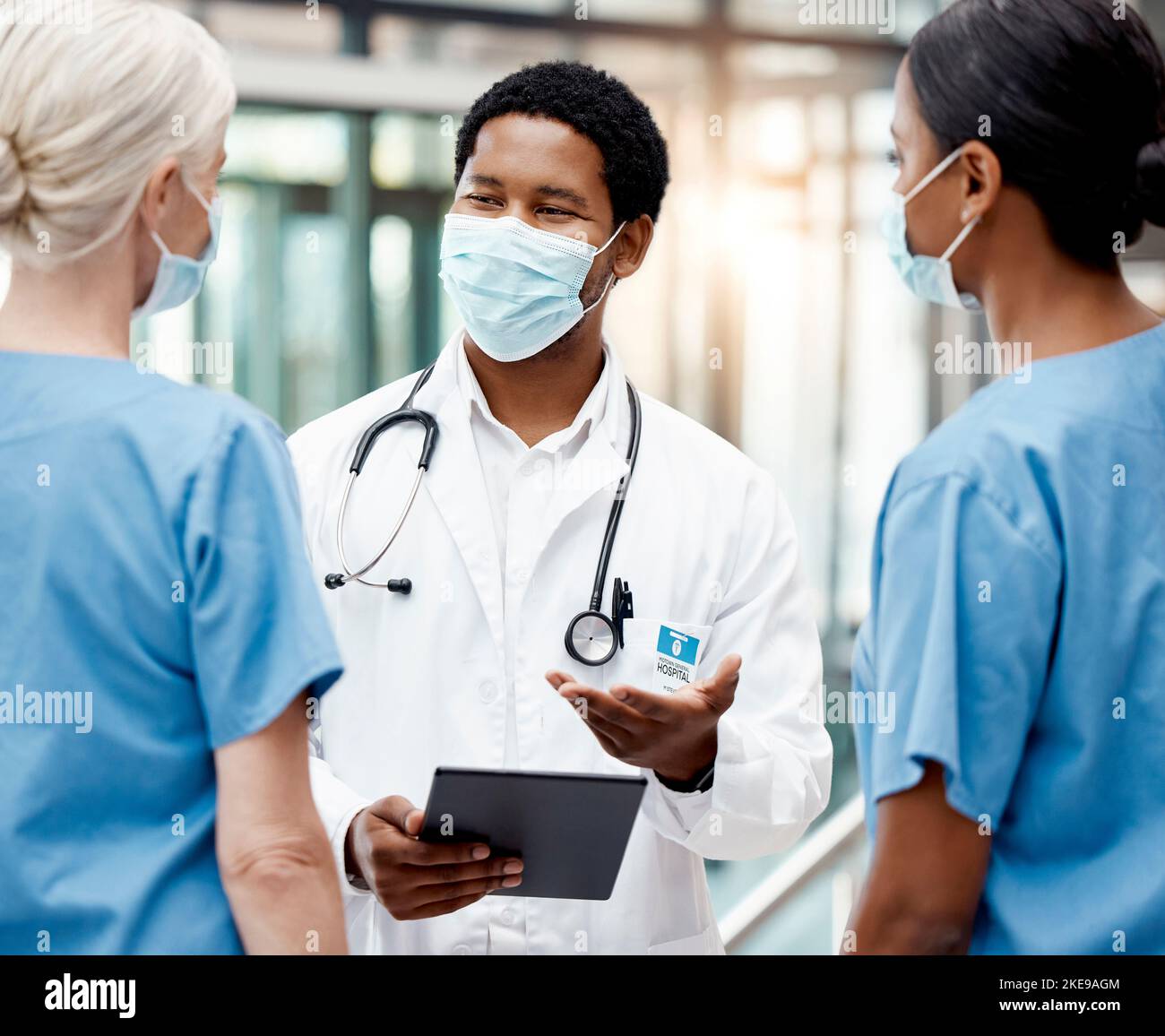Face mask, covid and team of doctors with tablet doing research or ...