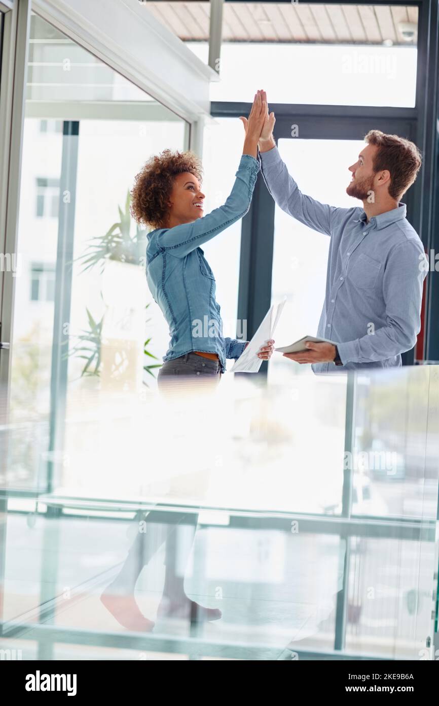 Celebrating a job well done. two colleagues high fiving each other in ...