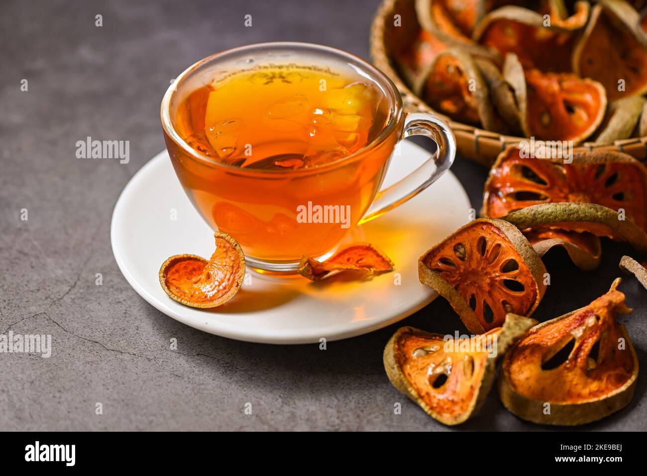 Bael tea on glass with dried bael slices on dark background, Bael juice ...