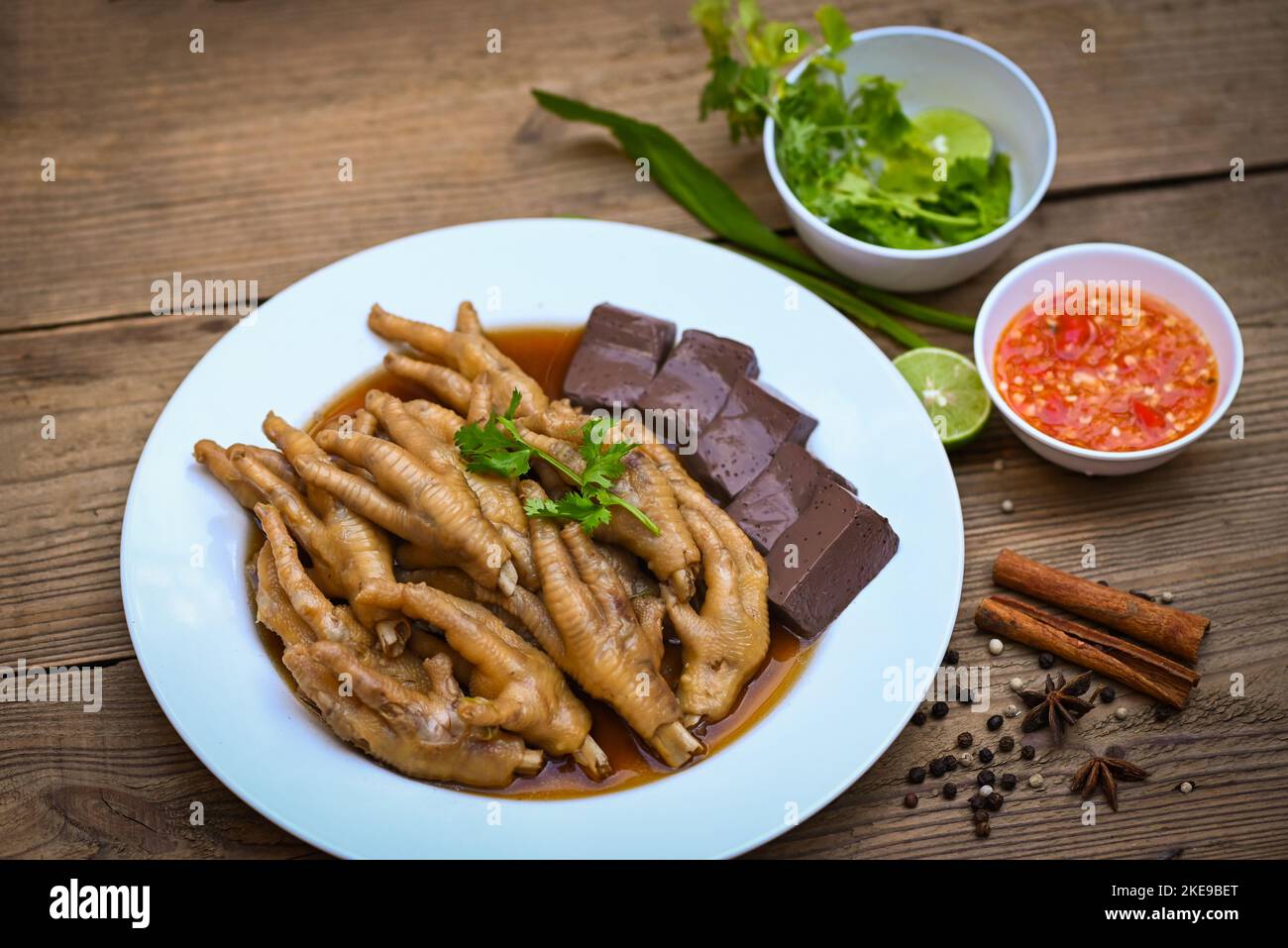 Cooking chicken feet foot stew on white with herbs and spices ...