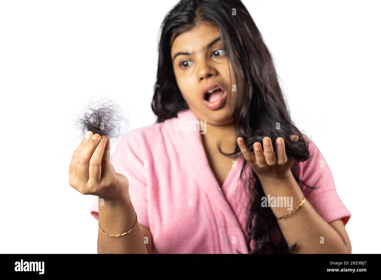 Selective focus on fallen hair held in hand by a worried Indian woman ...