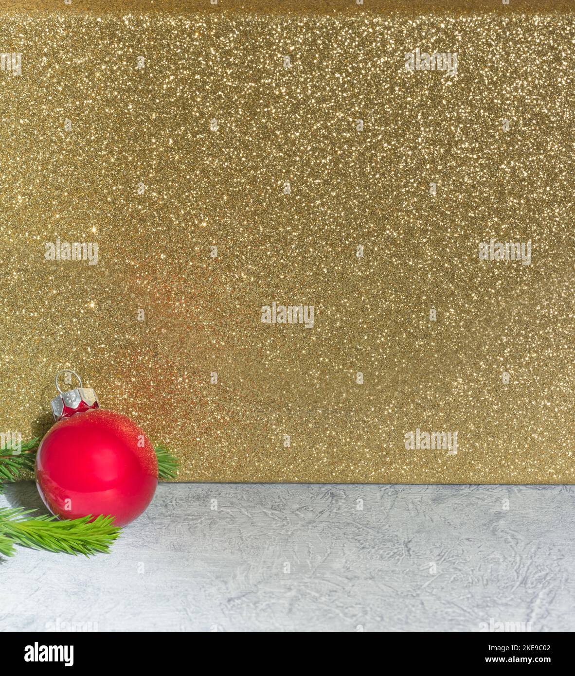 Gold tone background with copy space with red Christmas ball in ...