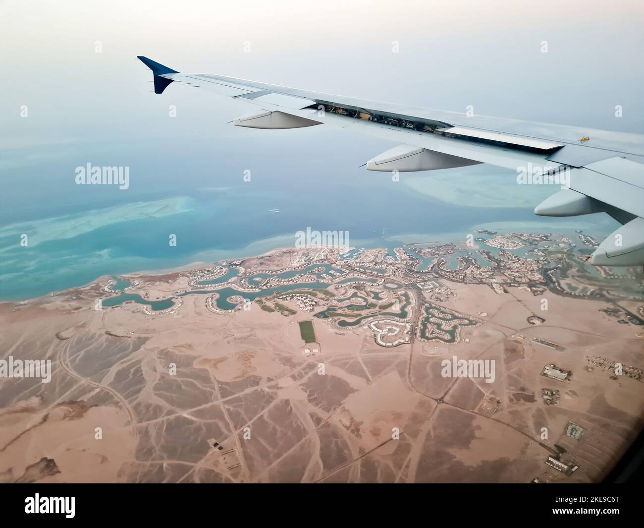 A bird's eye view of a beach against a turquoise sea seen from a plane ...