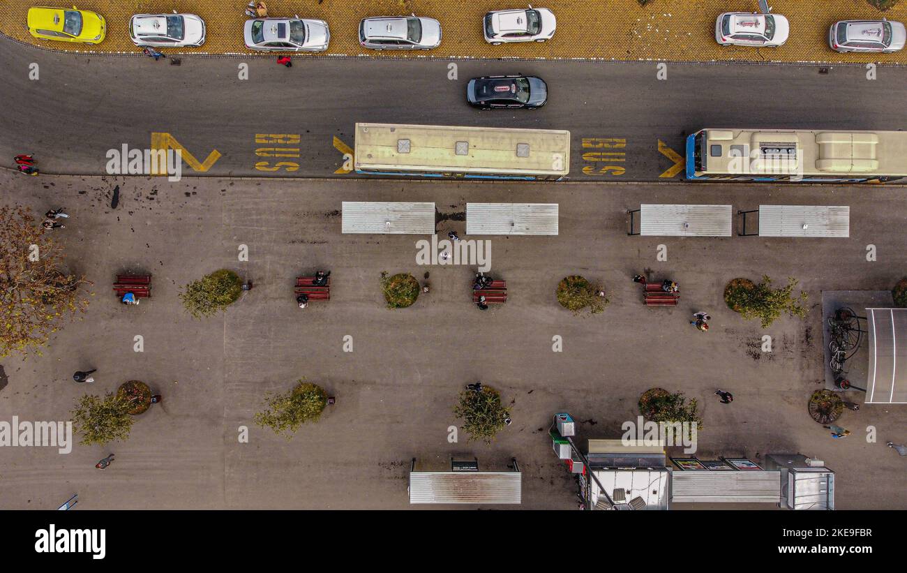 An aerial view of a road with buses and cars on it, and a sidewalk on ...