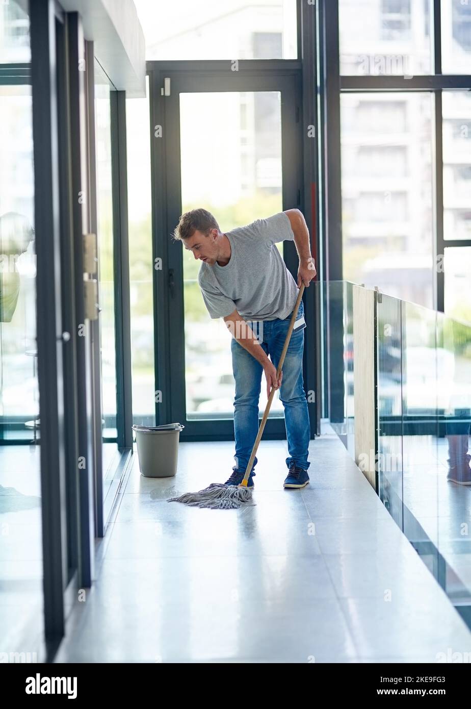 Itll shine like never before. a young man mopping the office floor ...