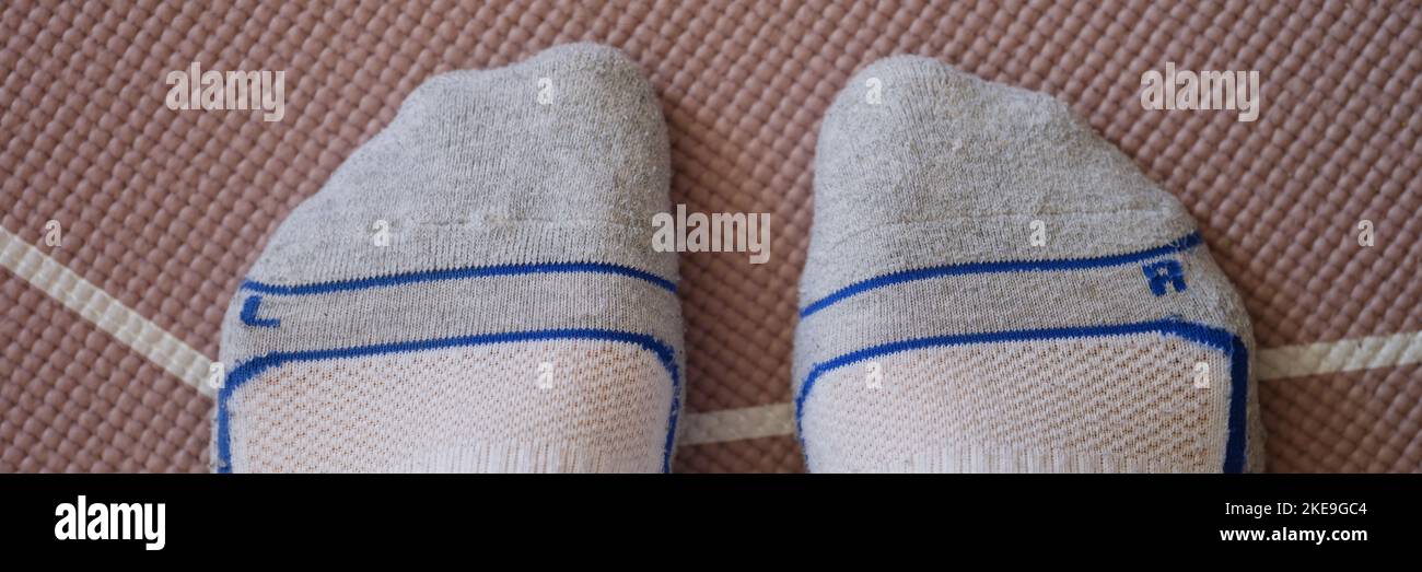Male feet in socks standing on yoga mat closeup top view Stock Photo ...