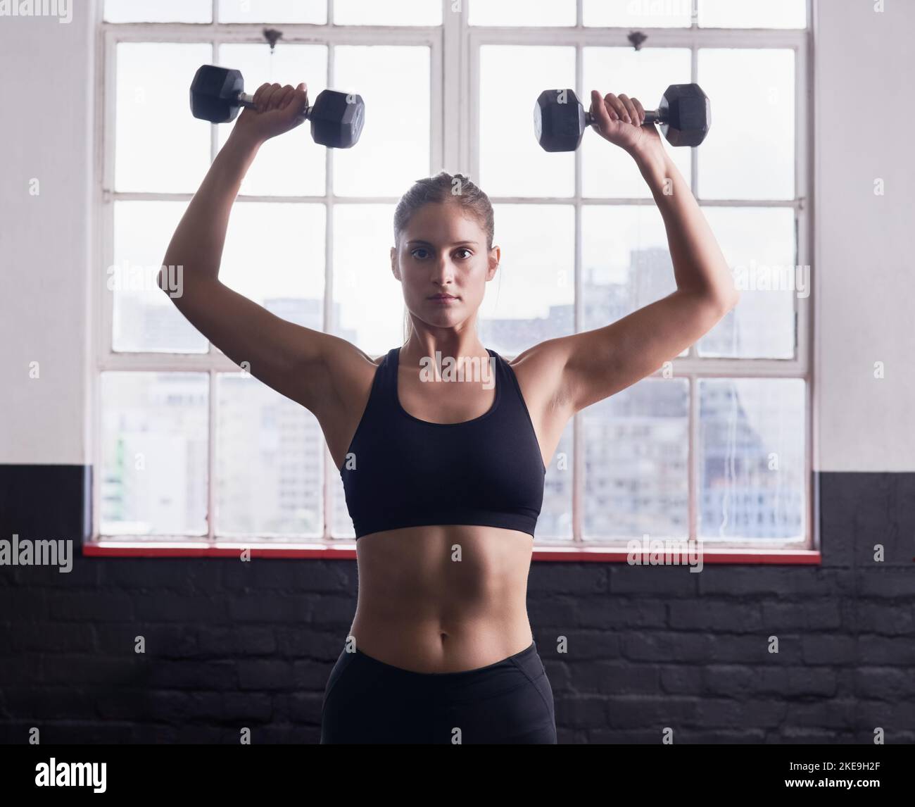 I hit the gym so I wont hit you. a young woman doing weight lifting ...