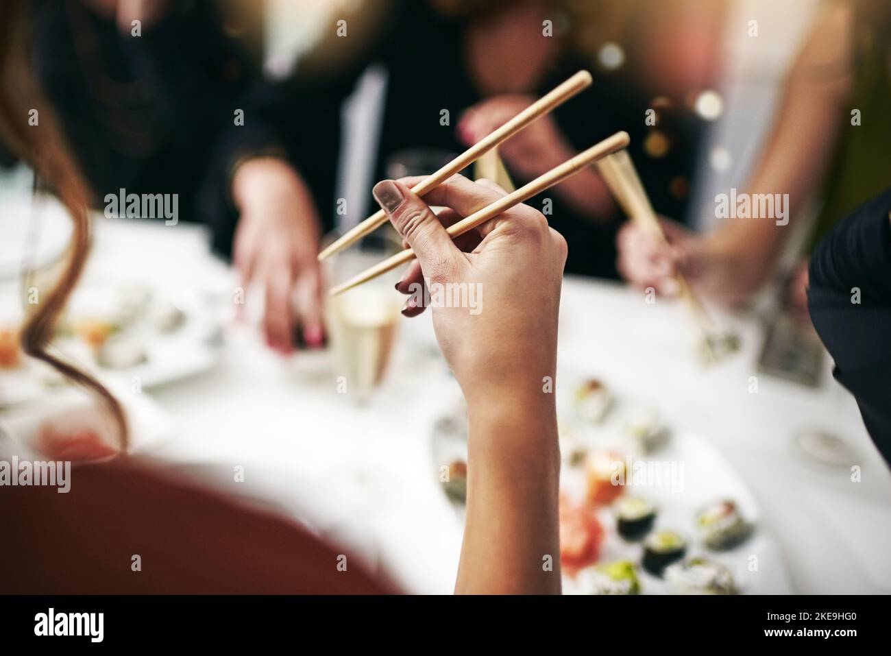 Trying her hand at using the chopsticks. an unrecognizable person ...