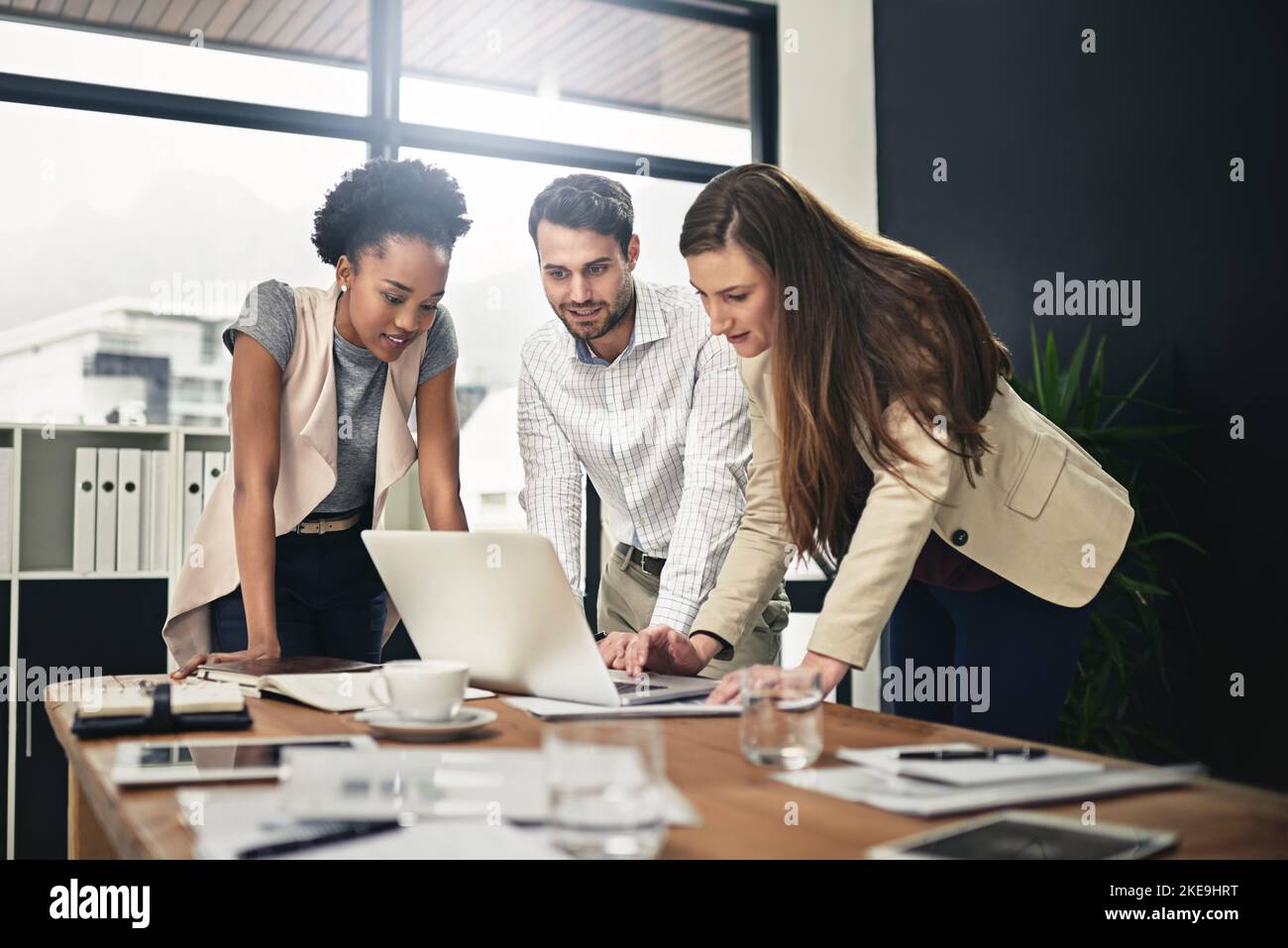 Together we achieve more in less time. a team of businesspeople using a ...