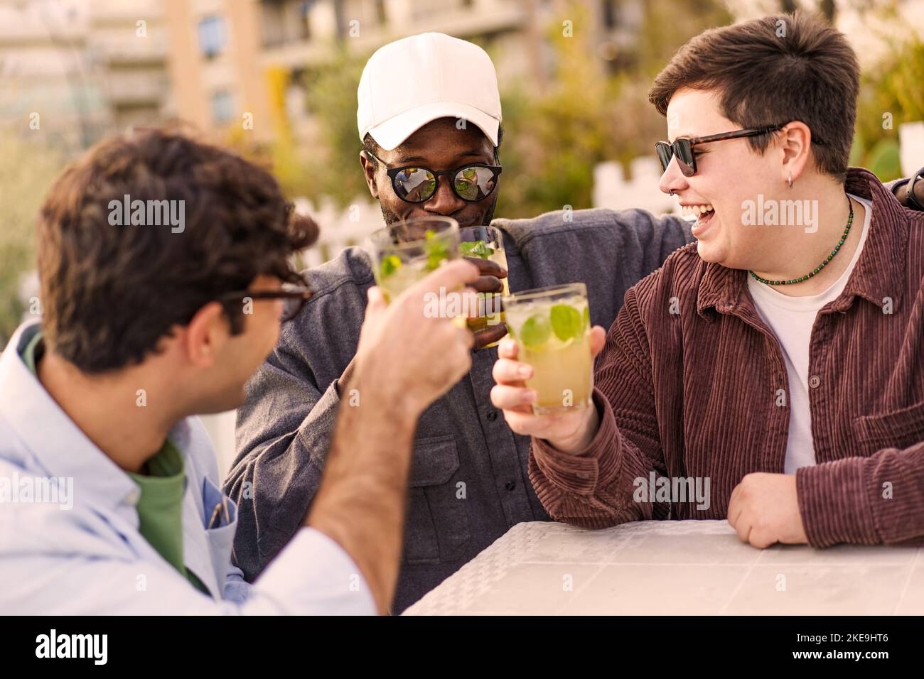 Happy positive friends cheering mojito drinks at cocktail bar pub ...