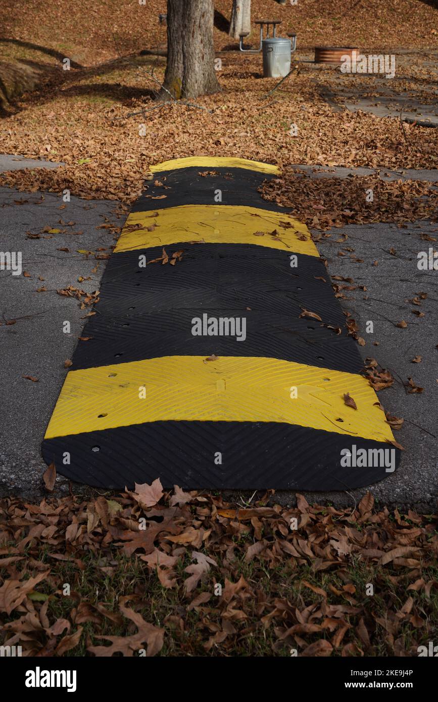 Rubber speed bump across road in campground Stock Photo - Alamy