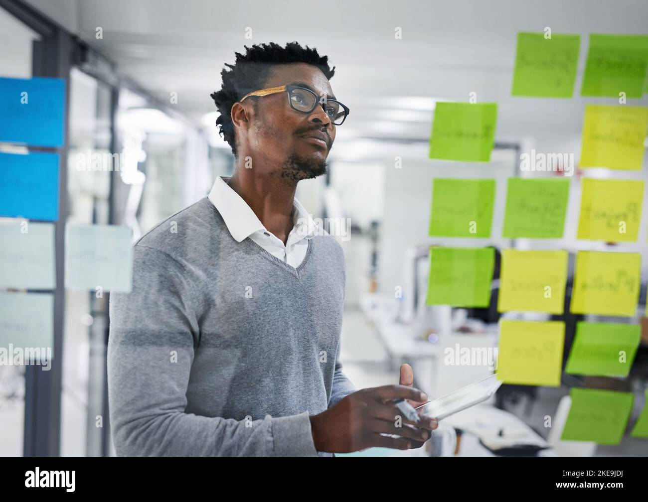 Putting his ideas into focus. a young businessman writing notes on a ...