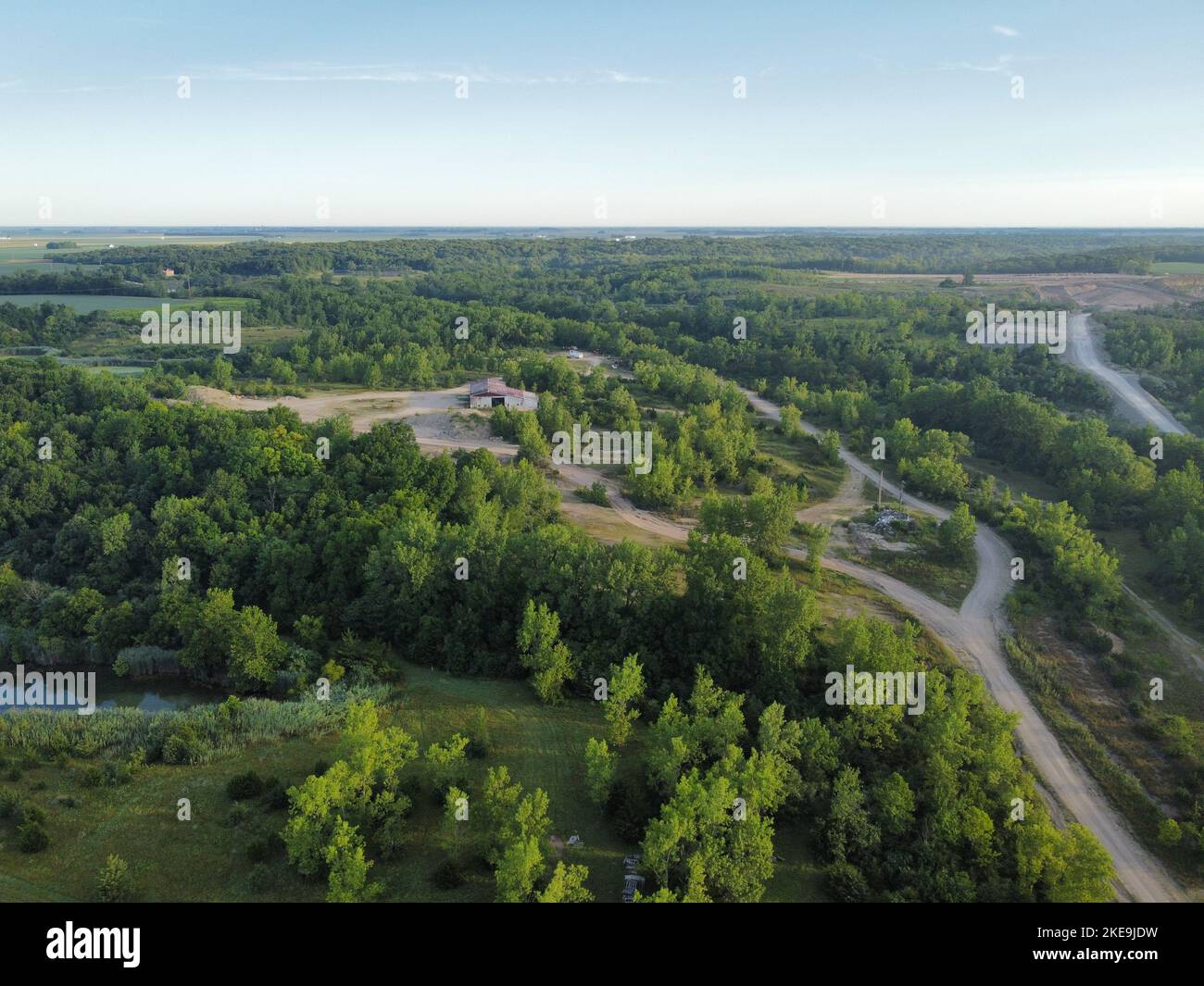 An aerial view of greenery field surrounded by dense trees Stock Photo ...
