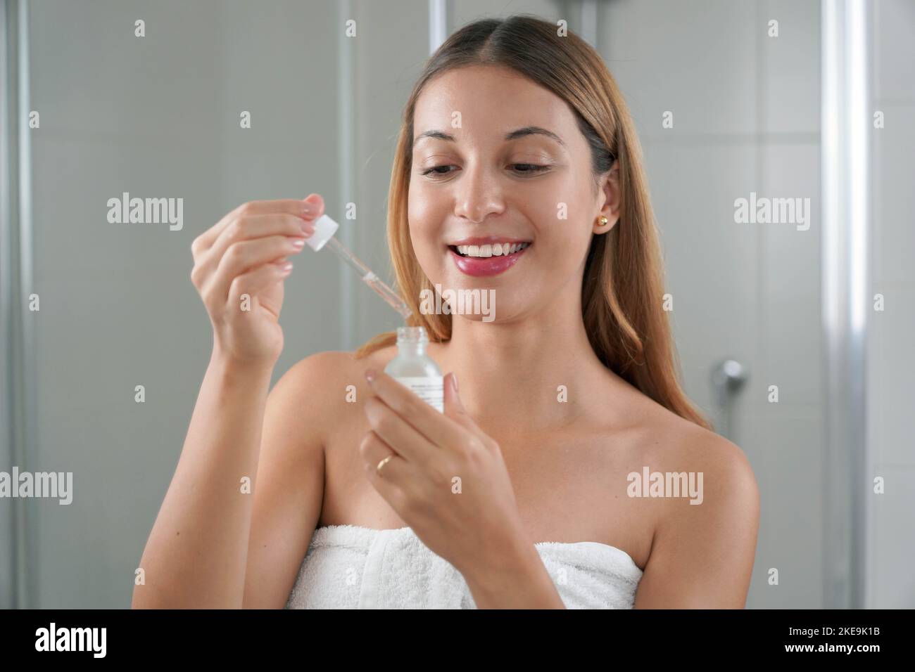 Happy young woman holding pipette ready to applying hyaluronic acid at ...