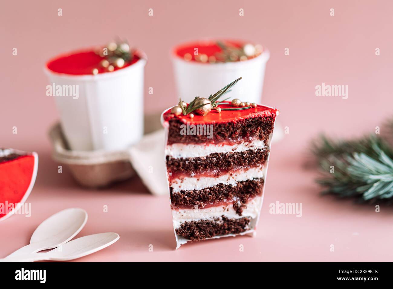 Whole and halved takeaway Christmas cake in white disposable cups ...