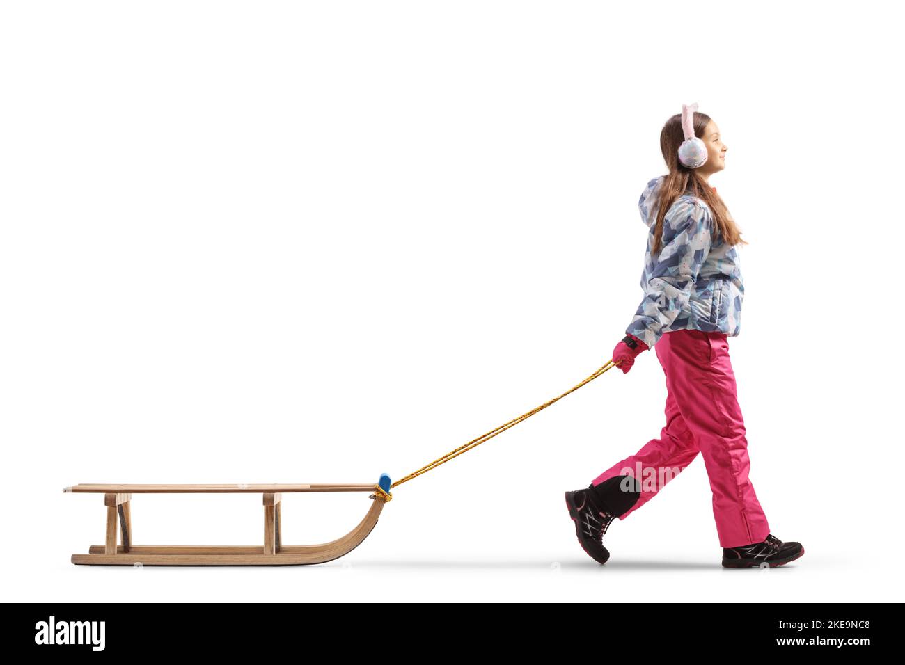 Full length profile shot of a girl pulling a wooden sleigh isolated on ...