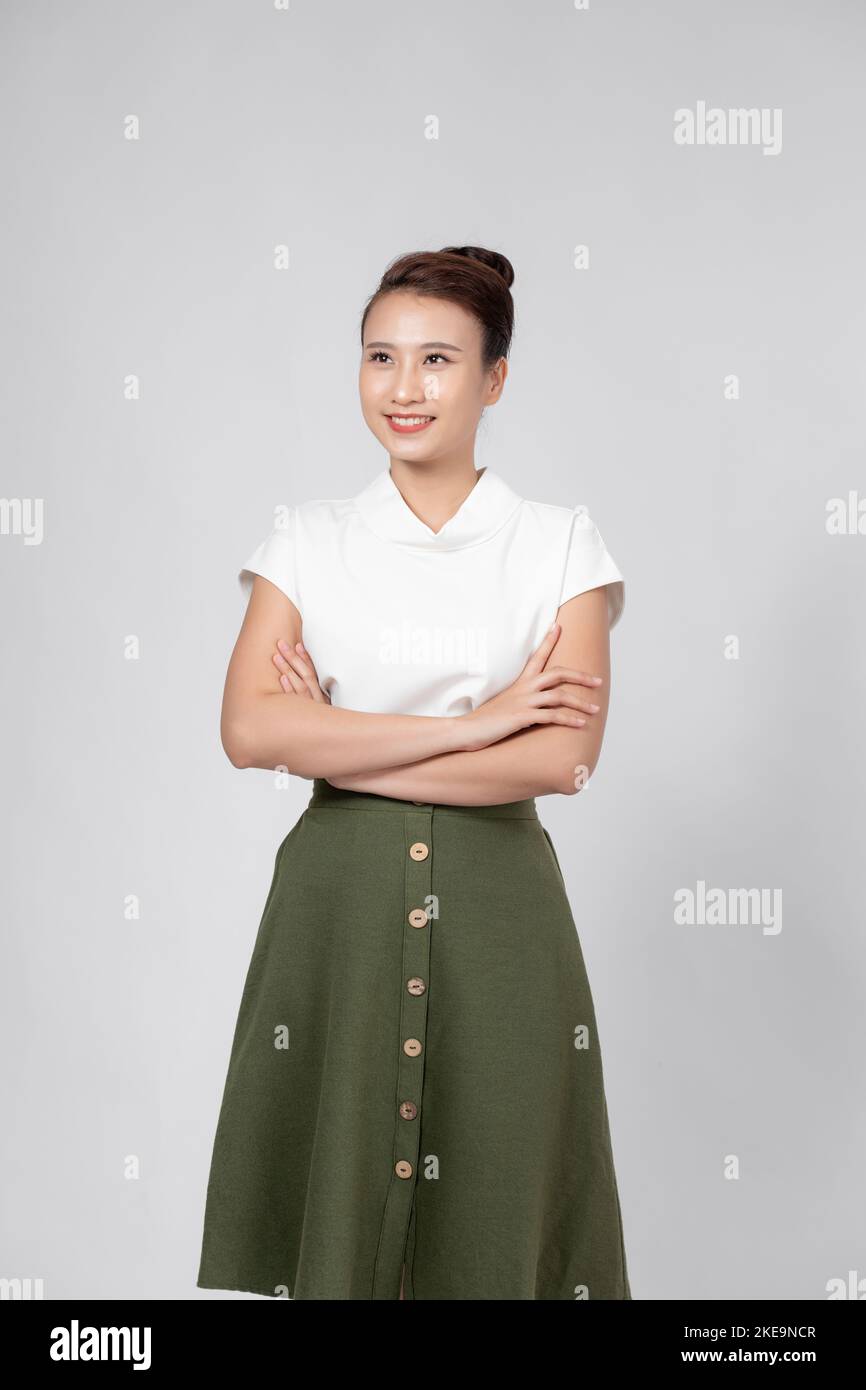 Beautiful girl with folded arms against white wall Stock Photo - Alamy