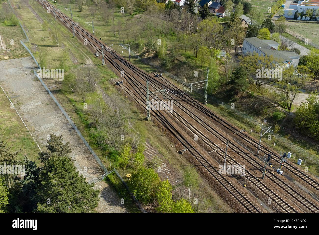 An aerial shot of empty parallel railways surrounded by grass in the ...