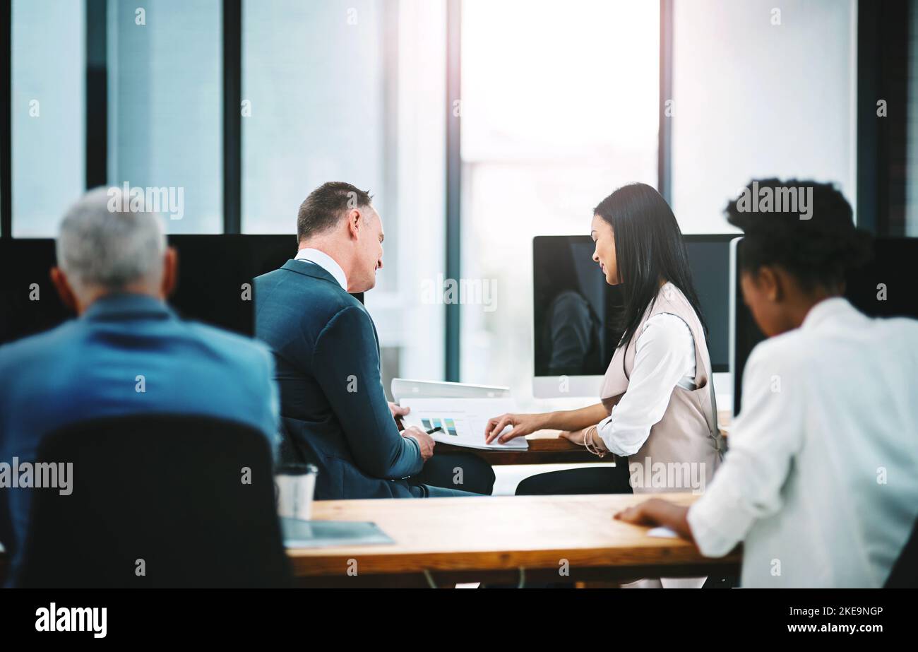 This is what a functioning office look like. Rearview shot of four ...