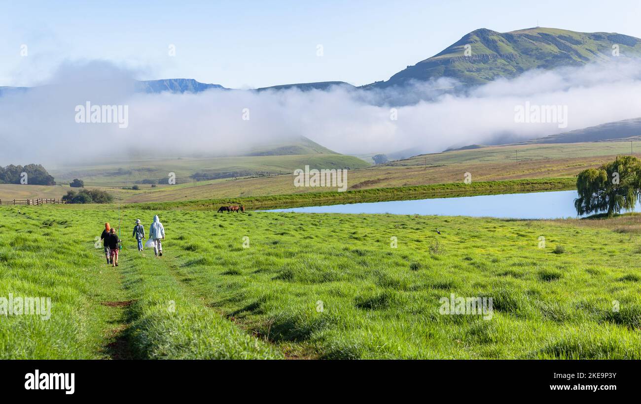 Going fishing distant young children walking down field green grass ...