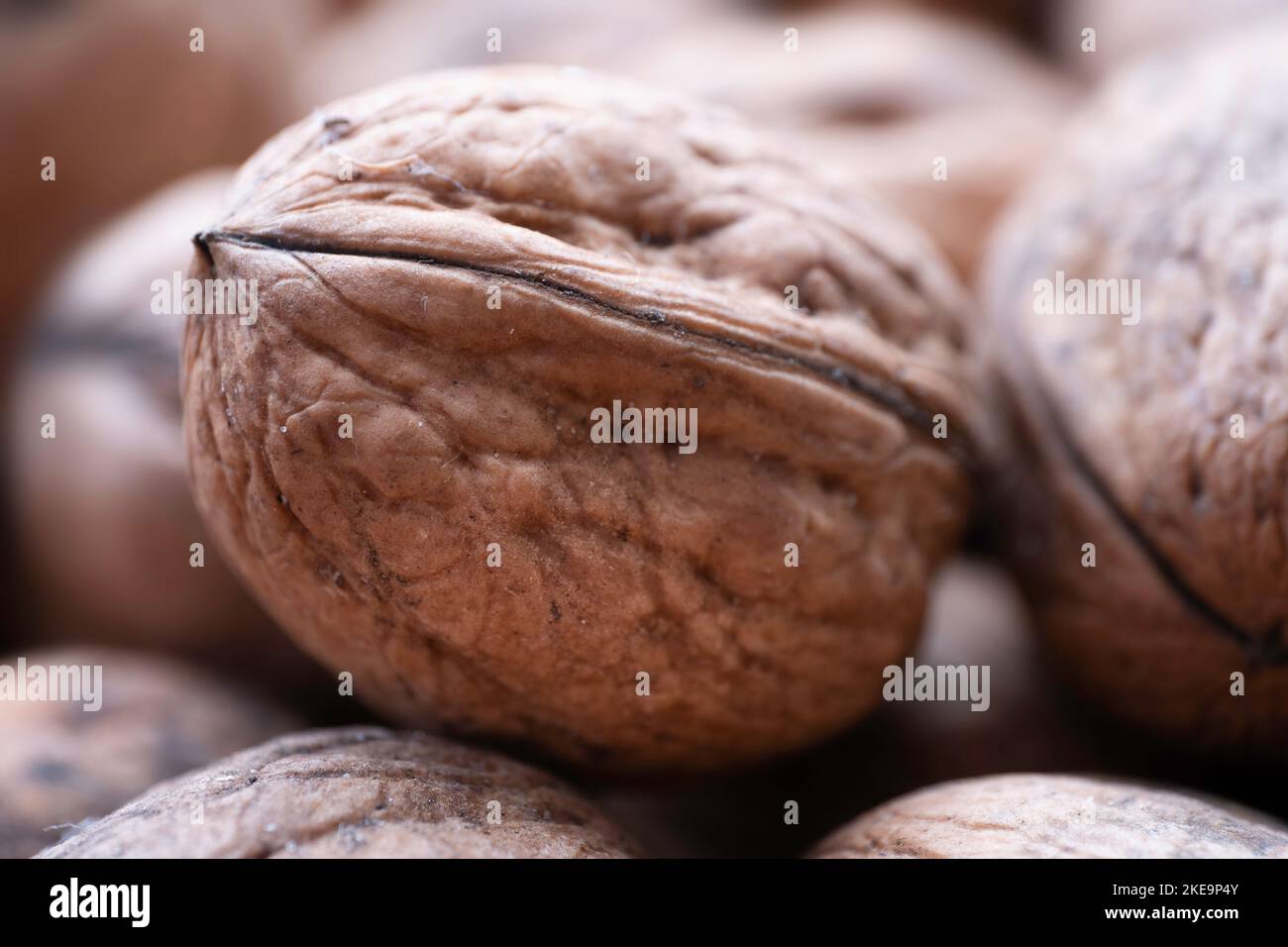 Walnut background. A few walnuts, narrow depth of field. Focus on the ...