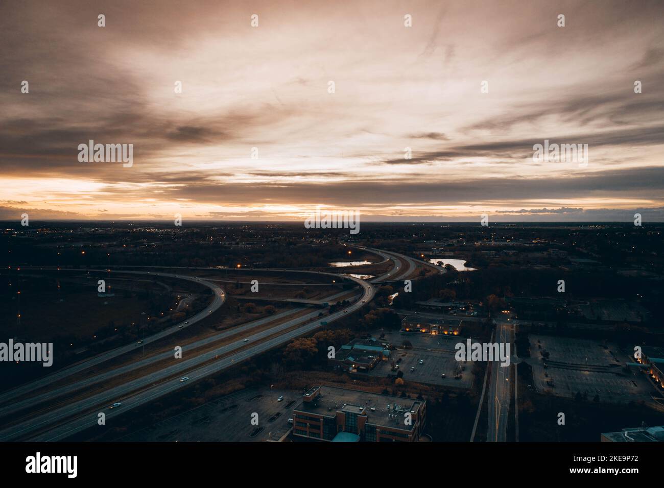 A high-angle shot of a suburban neighborhood next to a freeway exit ...