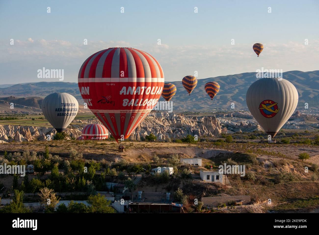 hot air balloons rise over the chimneys rock formation, Cappadocia ...