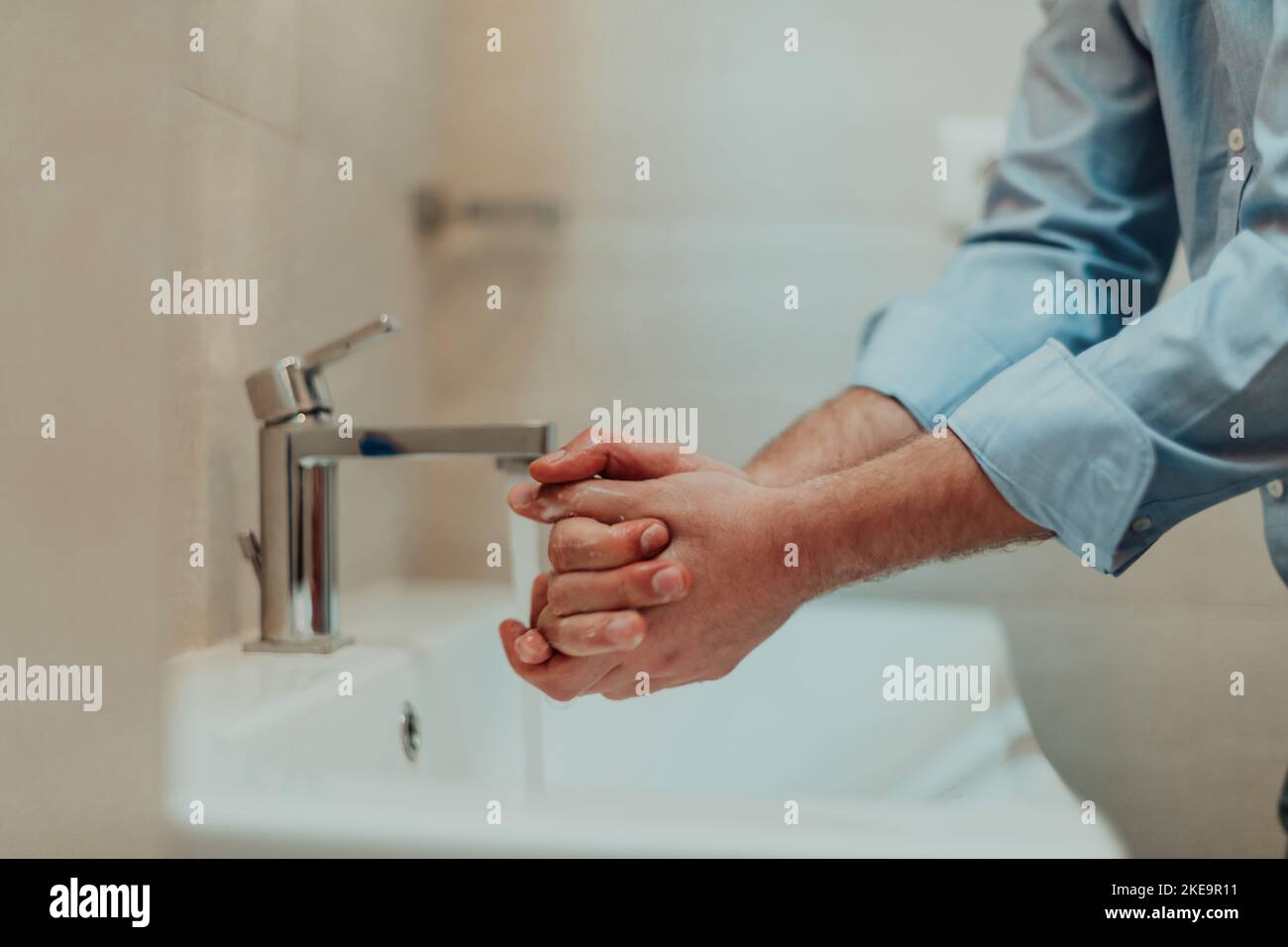 Man using soap and washing hands under the water tap. Hygiene concept ...