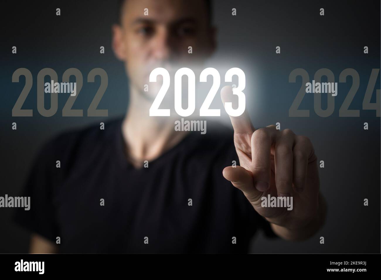 Finger pressing blue start 2023 button on virtual interface on gray ...