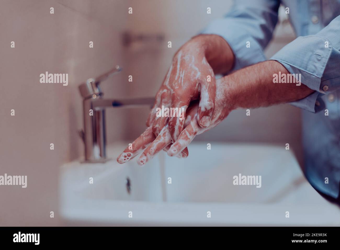 Man using soap and washing hands under the water tap. Hygiene concept ...